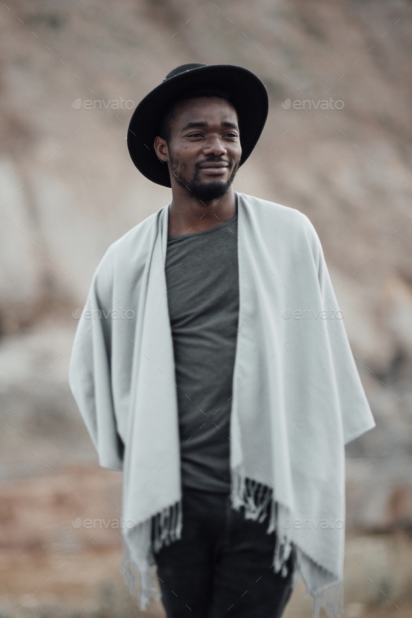 Handsome millennial black man in the desert in a black hat_ Stock Photo ...
