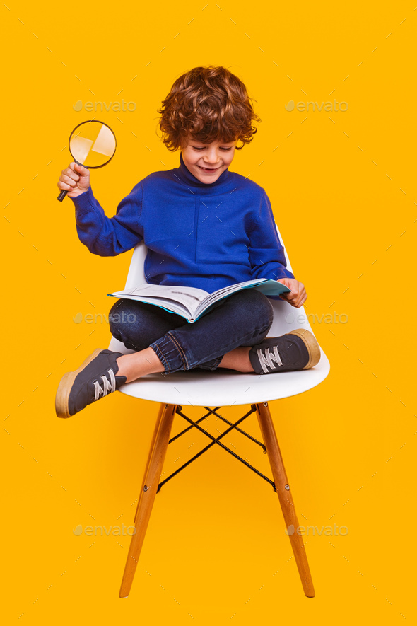 Smart boy reading book with magnifier Stock Photo by kegfire | PhotoDune