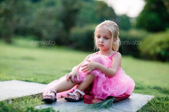 Happy little girl in pink tutu dress walking in the park Stock Photo by ...