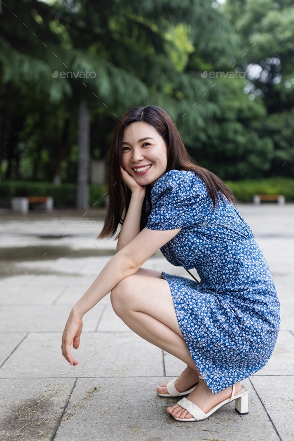Candid portrait of attractive asian woman which walks in urban park in ...