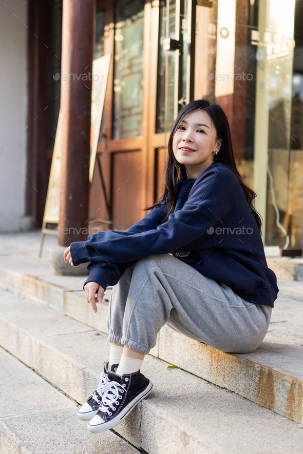 Happy stylish young asian generation z woman posing at fall season ...