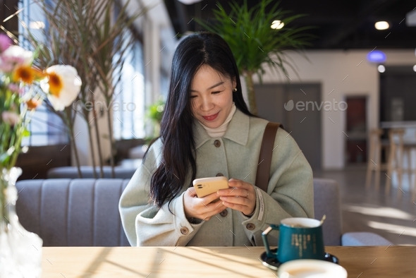 Happy stylish young asian generation z woman drinking coffee in small ...