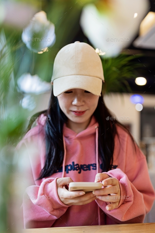 Happy stylish young asian generation z woman using technology in small ...