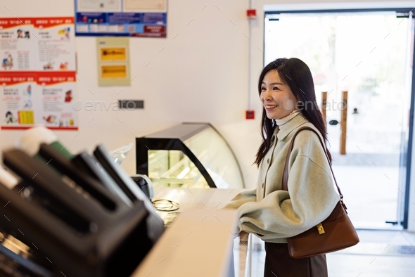 Happy stylish young asian generation z woman buying coffee in small ...