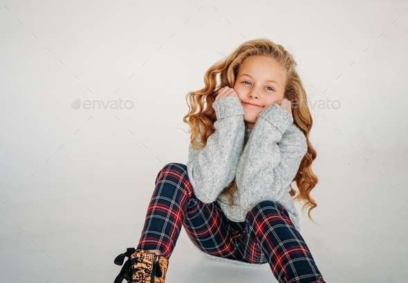 Beauty fashion portrait of smiling curly hair tween girl in cozy ...