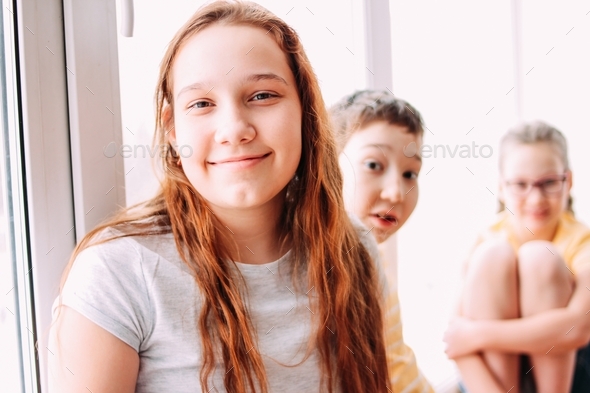 Three cute smiling children friends tweens sitting on window sill Stock ...
