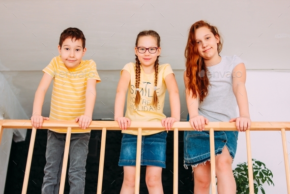 Three cute smiling children friends tweens on second floor at home ...