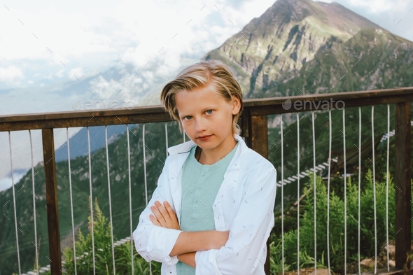 Blonde cold boy on observation deck on background of wonderful view of ...
