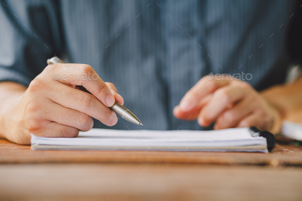 Man writing in a notebook. Write down important business data ...