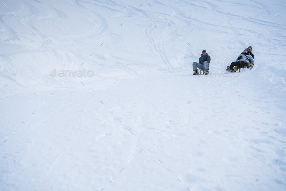 Crazy happy friends having fun with sledding on snow high mountains ...
