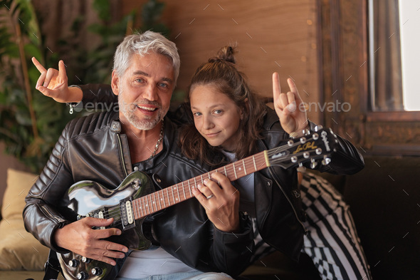 Father rock guitarist having fun and and dancing with his teenage ...
