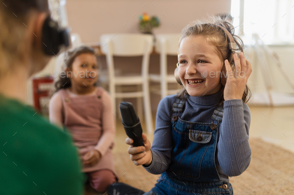 Little girls with headphones and microphone taking an interview, having ...