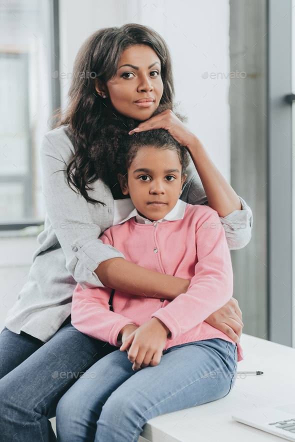 young african american mother hugging her daughter and looking at camera Stock Photo by ...