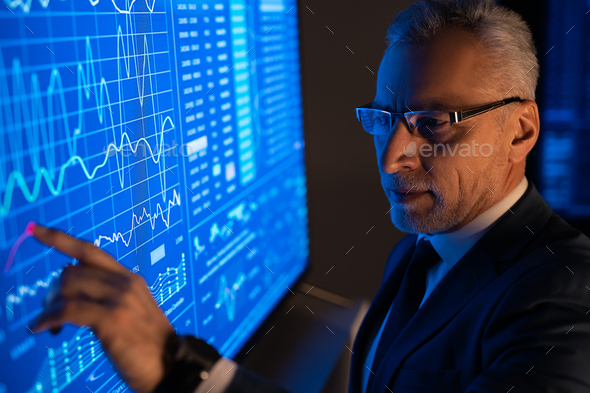 The old businessman working on the big blue screen with graphics Stock ...