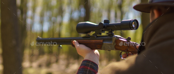 Hunter man aiming with rifle gun on prey in forest. Stock Photo by ...