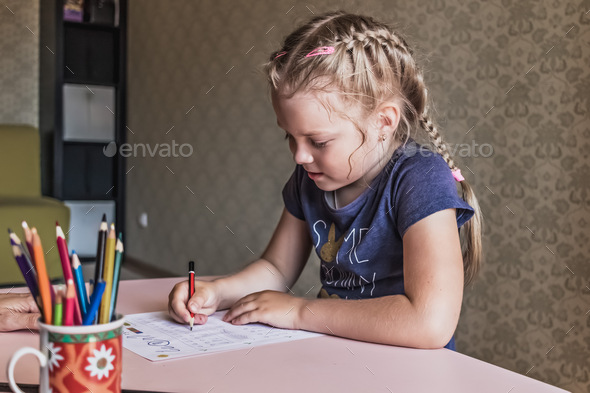 Girl solves math examples in class at school Stock Photo by svetlaya_83