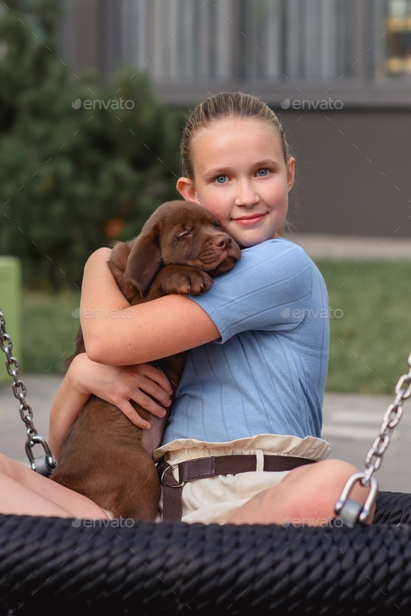 little girl with chocolate labrador puppy in the park Stock Photo by ...