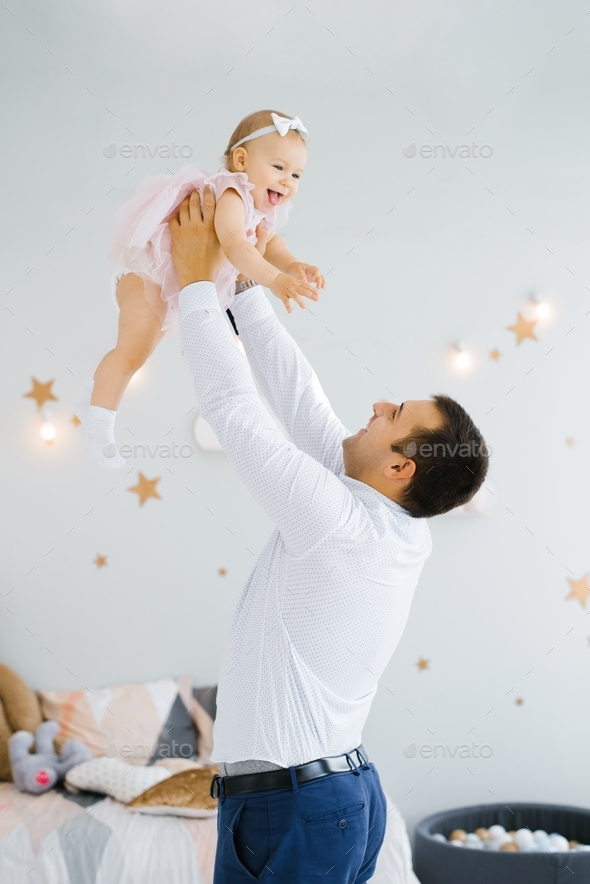 Father lifting baby girl. Happy father picks up and throws his lifting ...
