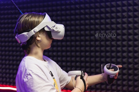 Young girl kid child playing VR game in glasses. Cyber space and ...