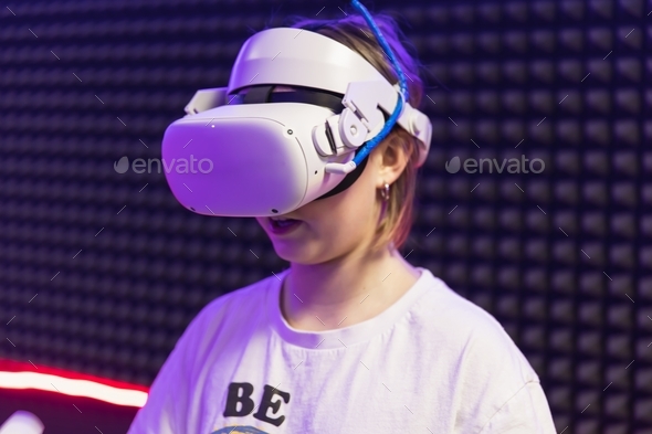 Young girl kid child playing VR game in glasses. Cyber space and ...