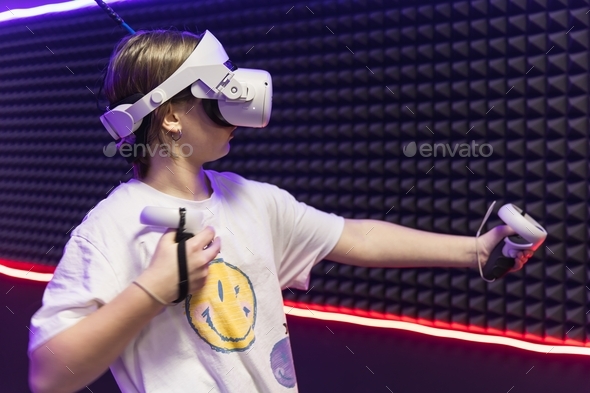 Young girl kid child playing VR game in glasses. Cyber space and ...