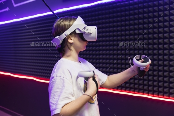 Young girl kid child playing VR game in glasses. Cyber space and ...