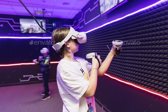 Young girl kid child playing VR game in glasses. Cyber space and ...