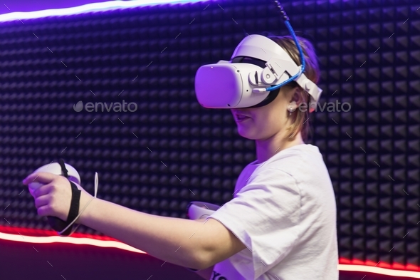 Young girl kid child playing VR game in glasses. Cyber space and ...
