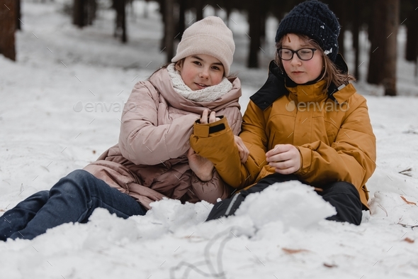 Children play in snowy forest. Toddler kids outdoors in winter. Friends ...