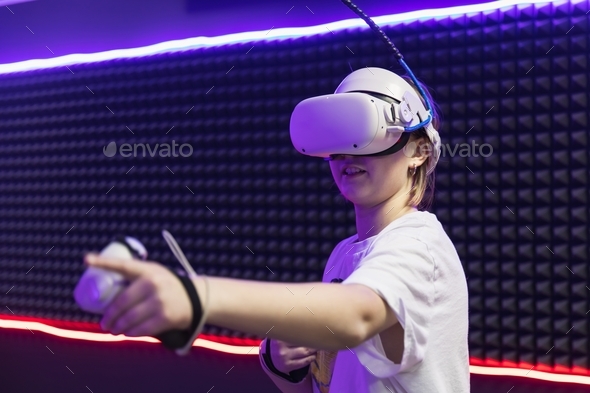 Young girl kid child playing VR game in glasses. Cyber space and ...