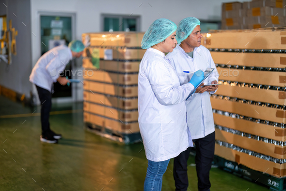 In warehouse quality control team checking drinking bottle stack on ...