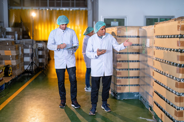 In warehouse quality control team checking drinking bottle stack on ...