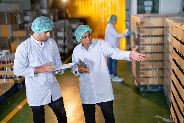 In warehouse quality control team checking drinking bottle stack on ...