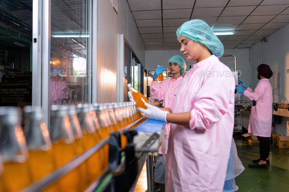 Beverage worker in drink factory stand working near drinking bottle ...