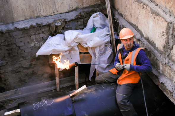 Welding work, man welder welds the pipeline at the construction site. N ...