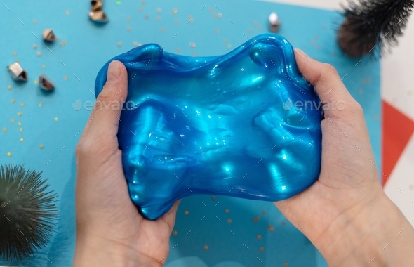 Kid playing with slime, child making slime on blue Christmas background ...