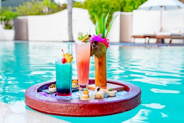 served floating tray in swimming pool with drinks and snacks on ...