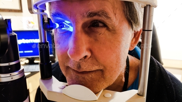 Shining a light into a man's eyeball in the doctors office using neon ...