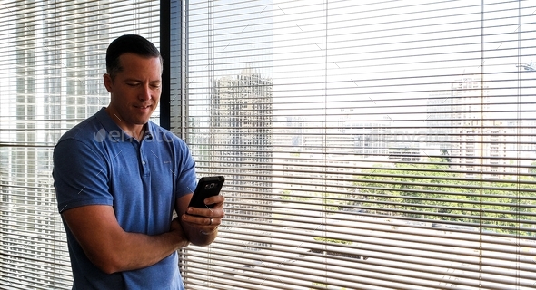 Banker is in his new office next to window view of Atlanta skyline ...