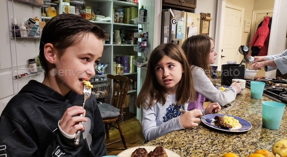 Gen z kids eating breakfast on kitchen counter together before back to ...