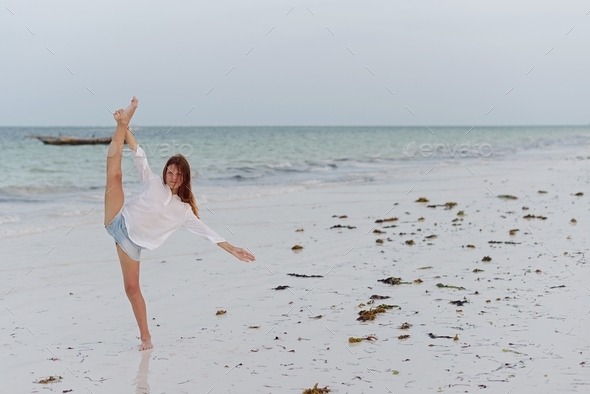 teen gymnast girl shows splits on the beach and having fun, Zanzibar ...