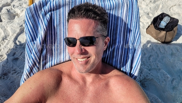 Young man laying down in beach chair enjoying the Florida sunshine ...