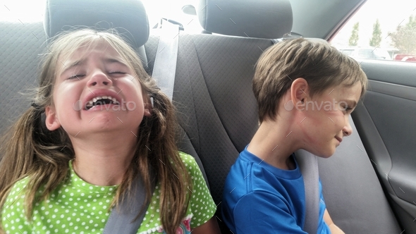 Kids being kids in backseats of car driving with emotions on faces of ...