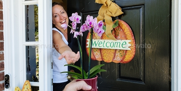 Millennial homeowner as people in fall welcomes a visitor bringing ...