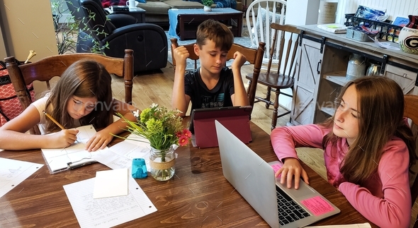 Generation z kids working on class assignments using laptops and mobile ...