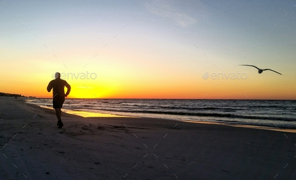 Beautiful sky at sunrise in beach landscape with jogger in morning ...