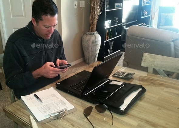 Guy using multiple devices in home office. Stock Photo by Beachbumledford
