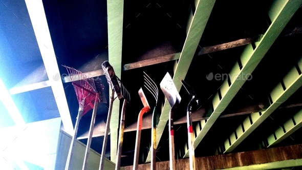 Landscaping truck with rakes and shovels drives under a bridge in ...