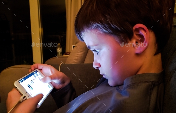 Gen z kid watching video game on his cellphone in his home sweet home ...