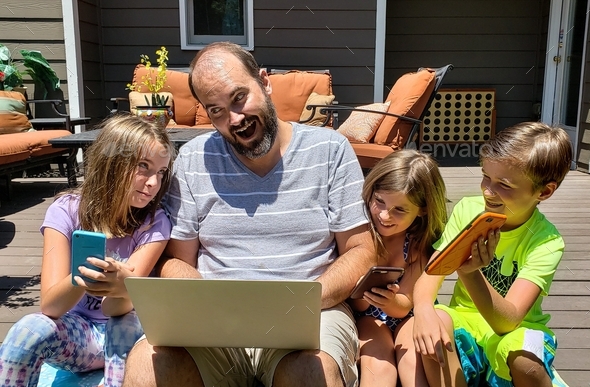 Millennial dad with generation z kids using mobile devices in family ...